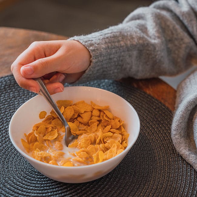 girl eating cereal saying help